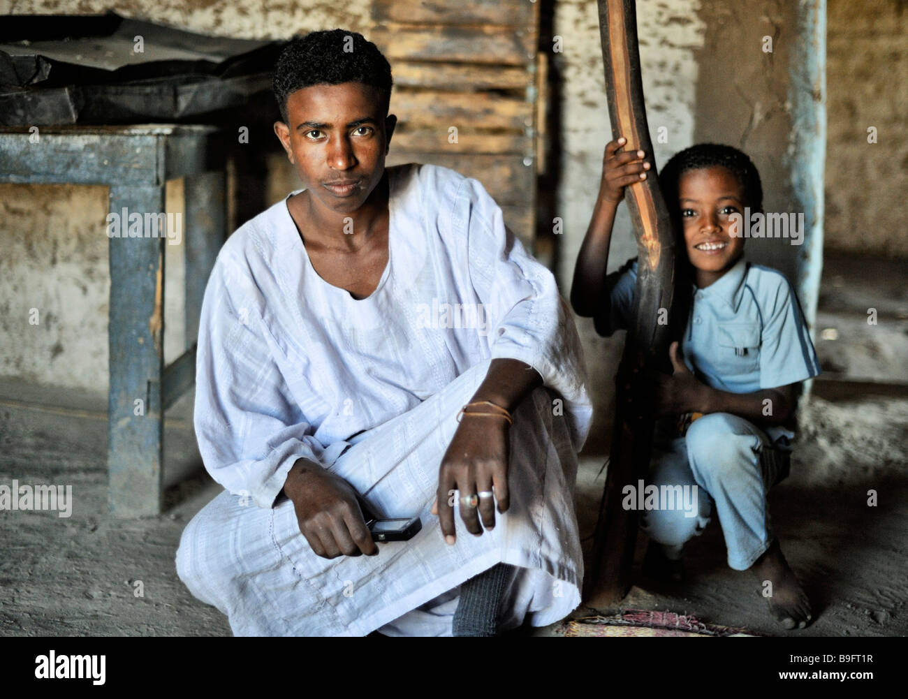 Sudanese man with his young son, and holding mobile telephone ...