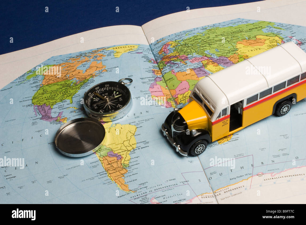 A toy bus and compass on a world map Stock Photo - Alamy