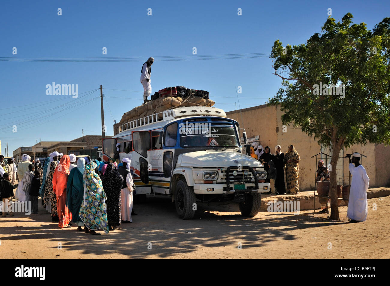 old sudanese bus being loaded with people and goods before it leaves ...