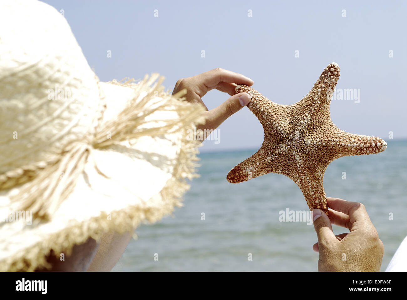 Man sitting lake starfish Stock Photo - Alamy