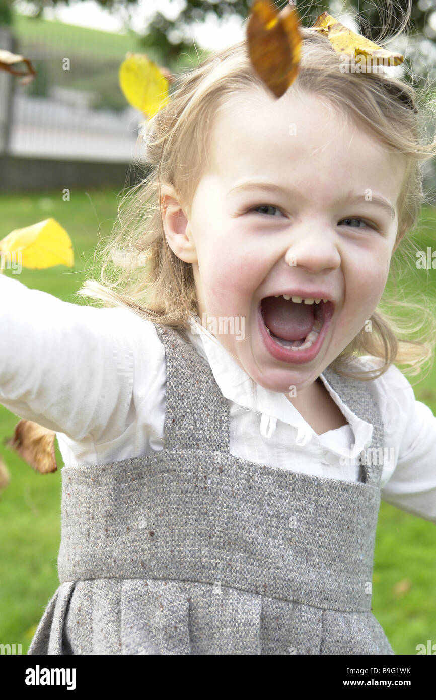 Garden girl fall foliage throws up frolic portrait series child toddler ...