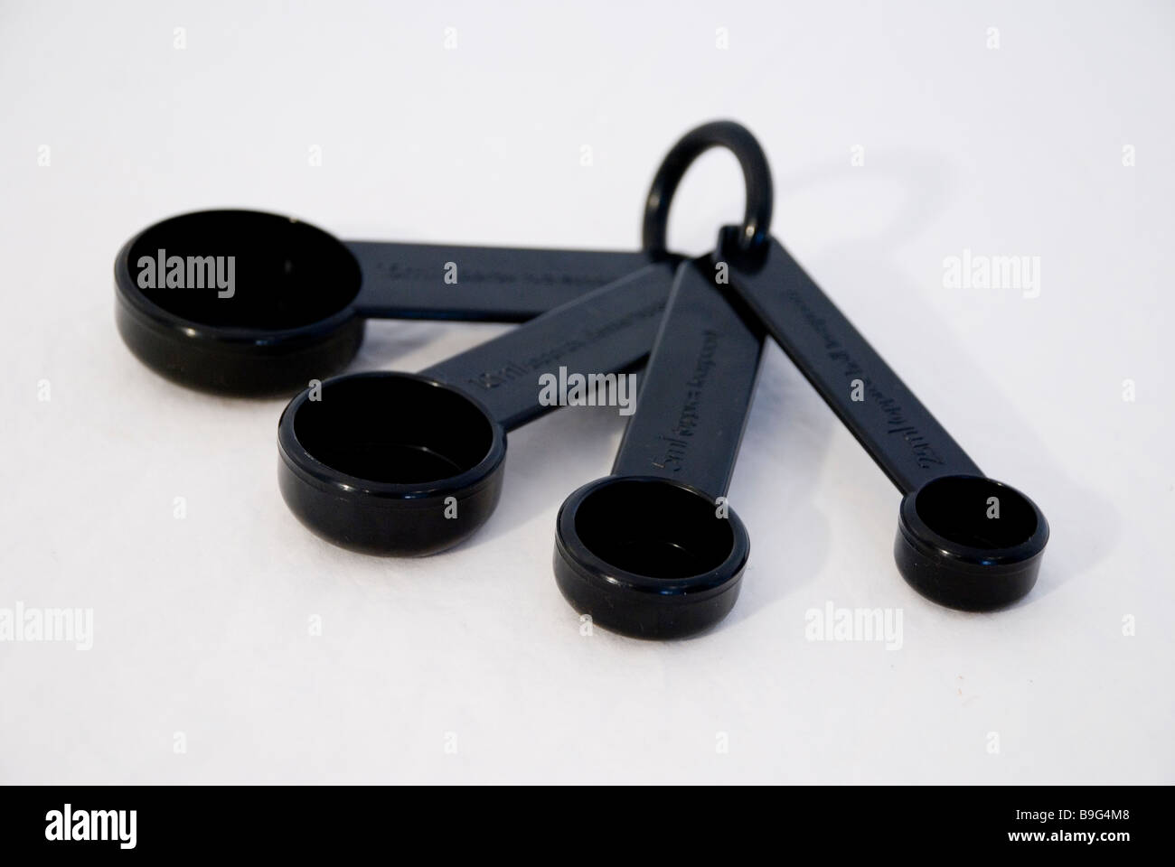 4 Measuring spoons in black plastic on a white background Stock Photo ...