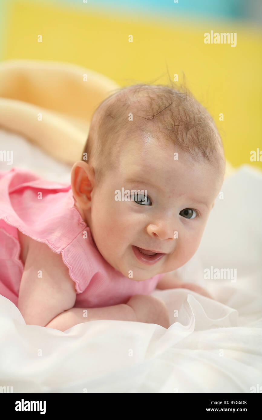 Baby lying prone position head lifts smiling portrait 4 months wakened ...