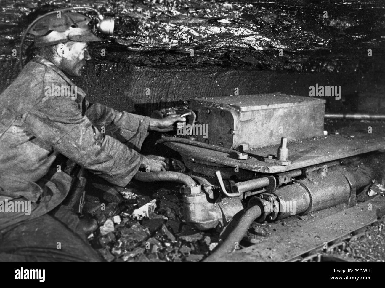 Miner operating the Donbass coal plough machine Stock Photo - Alamy