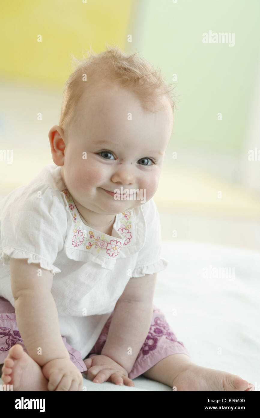 Baby sitting head-on smiling Stock Photo - Alamy