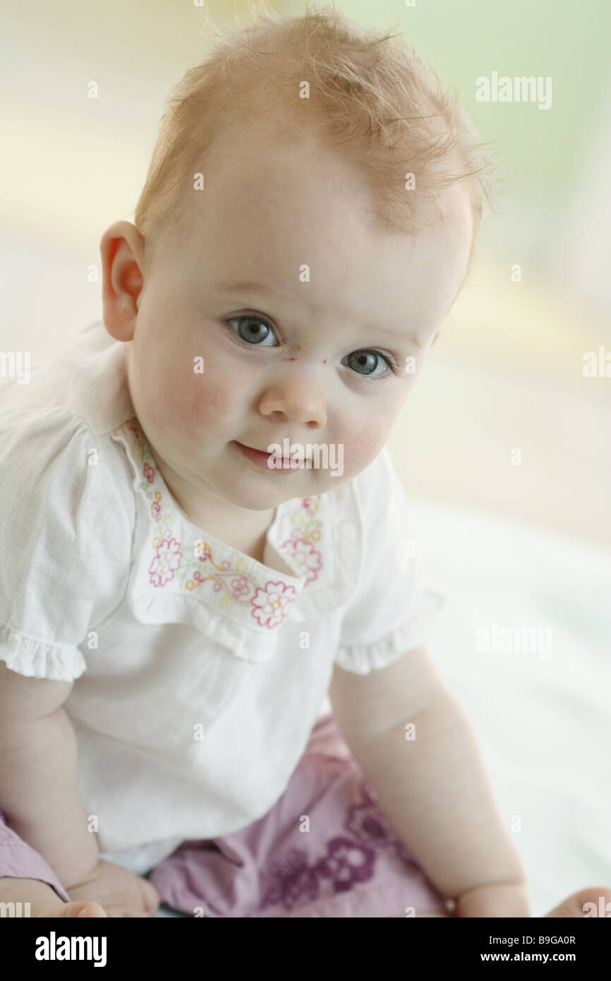 Baby sitting smiling friendly Stock Photo - Alamy