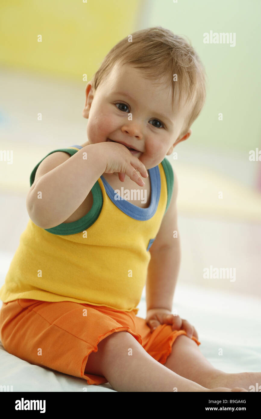 Baby sitting sidewards watching camera kindly gesture 10 months wakened ...