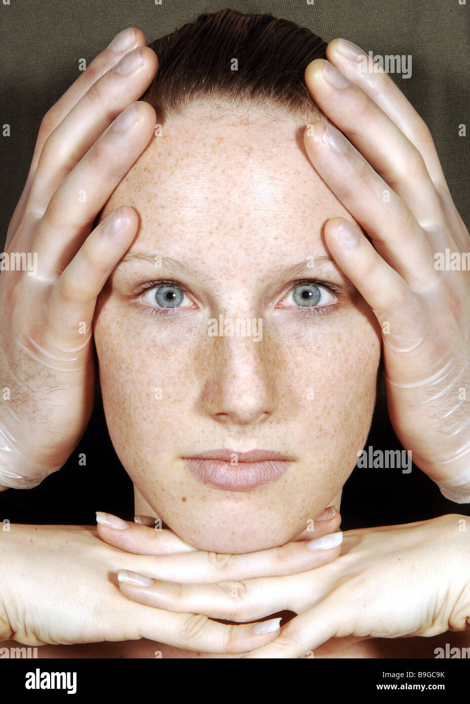 Woman young freckles portrait man's-hands latex-gloves head touch ...