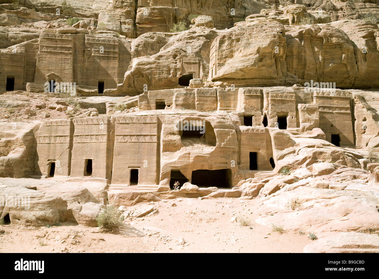 A lone tourist sitting in one of the tombs in Petra, Jordan Stock Photo ...