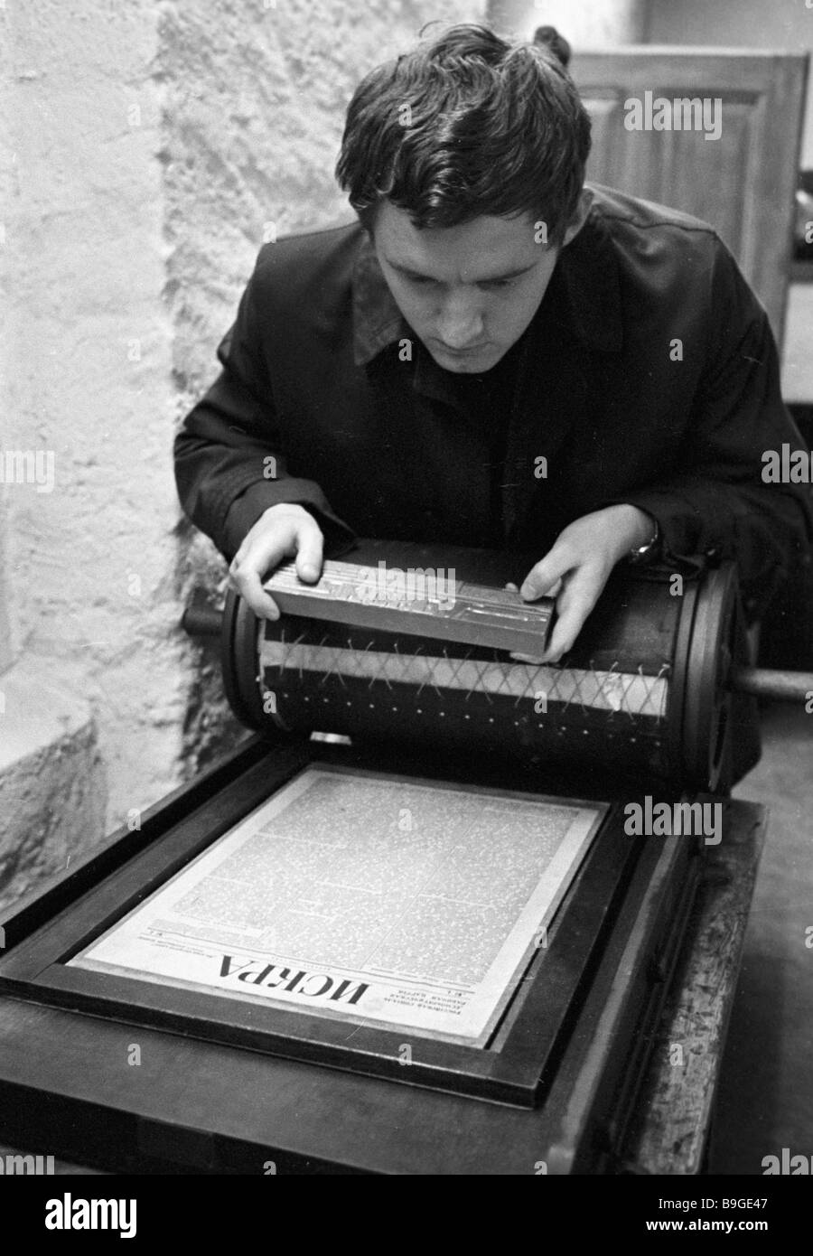 A visitor of Iskra newspaper museum examining a manual printing machine ...