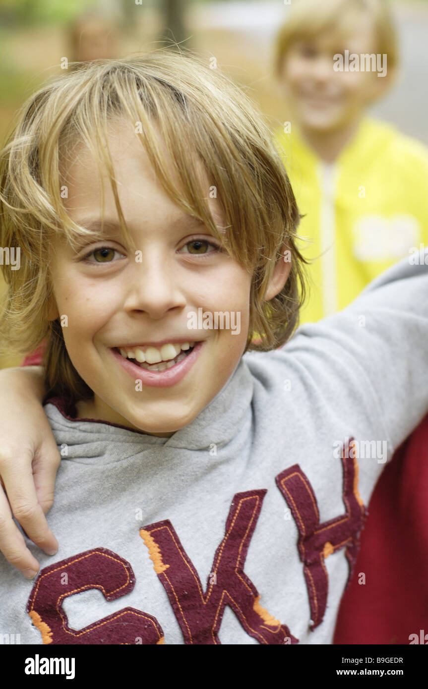 Child boy cheerfully laughs buddies embrace detail outside portrait ...