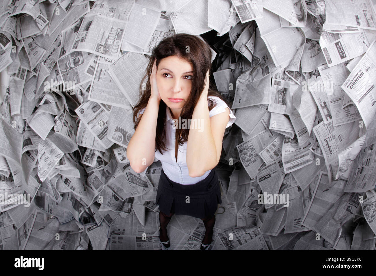 Enough withe the news. Business woman surrounded by newspapers covering ...