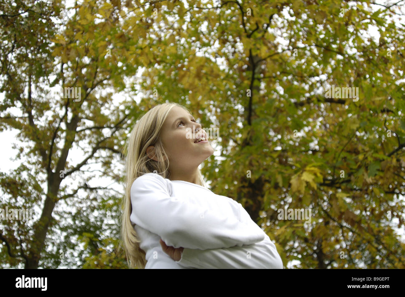 Child girl poor forest crosses stands high-looks smiling happily dreams ...