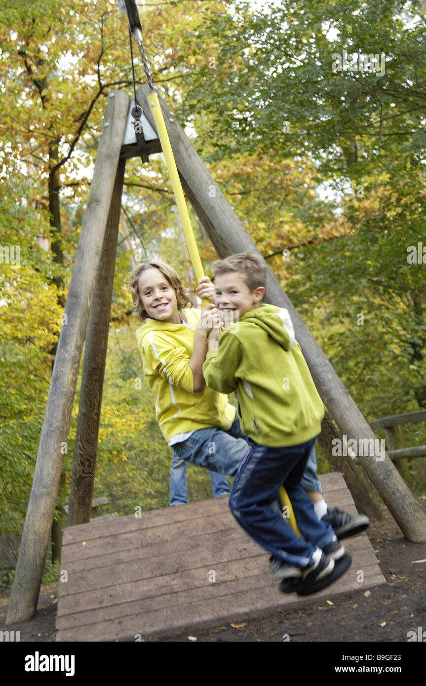 Children boys forest playground play does gymnastics laughs cheerfully ...