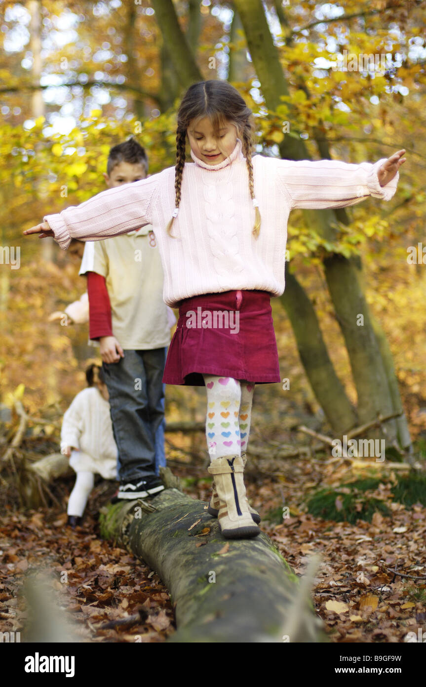 Children girl boy autumn forest plays log balances friends 6-10 years ...