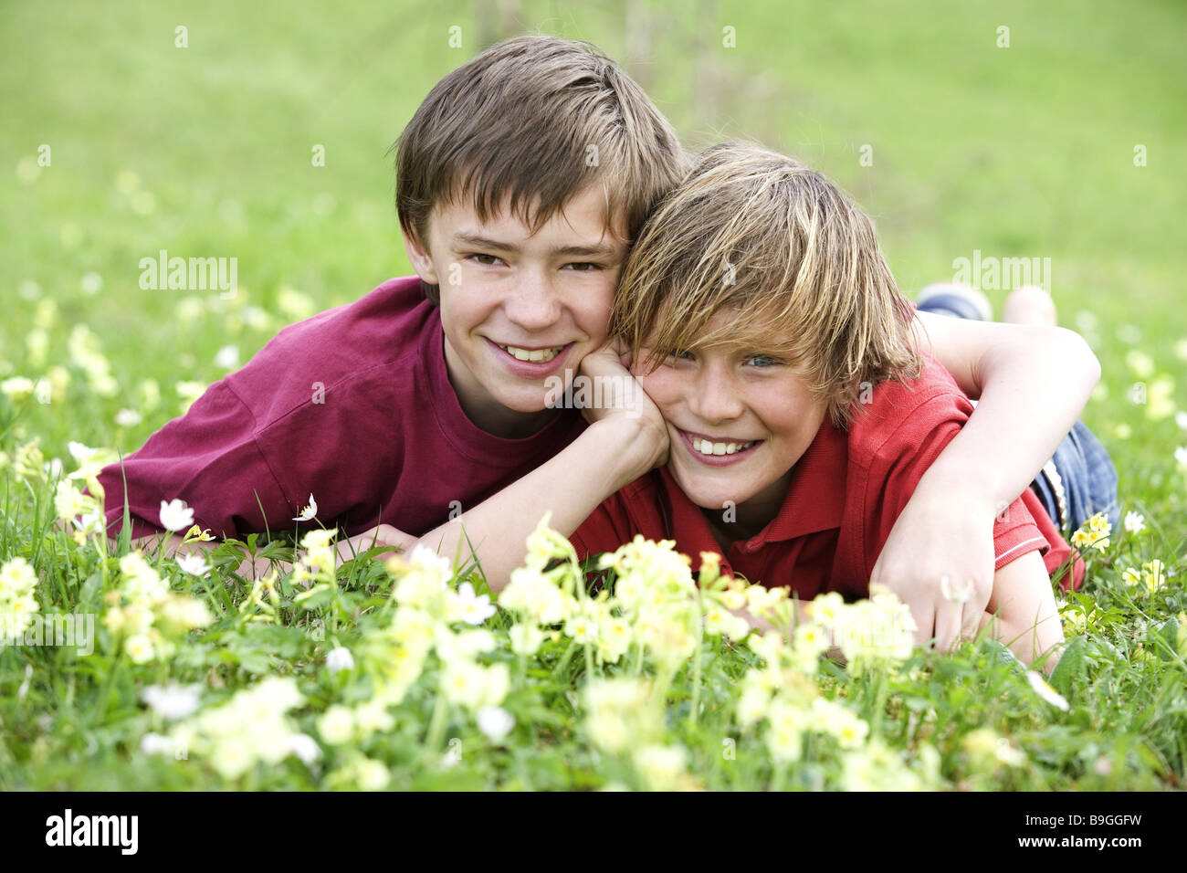 Meadow boys cheerfully lying embrace portrait people 11-13 years ...