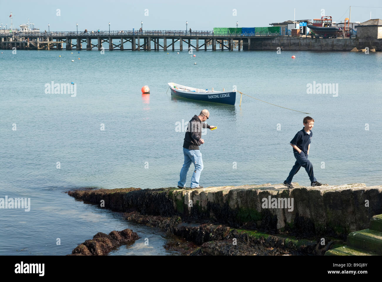 Father and son fishing off breakwater at Swanage Stock Photo - Alamy