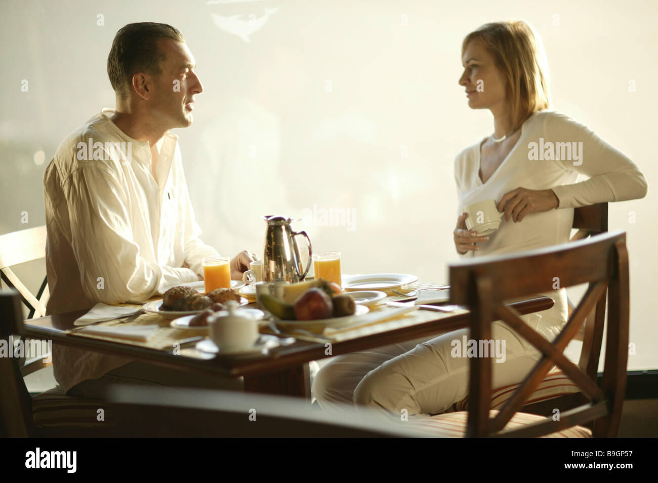 Mate sitting breakfast-table entertains opposite semi-portrait 40-50 ...