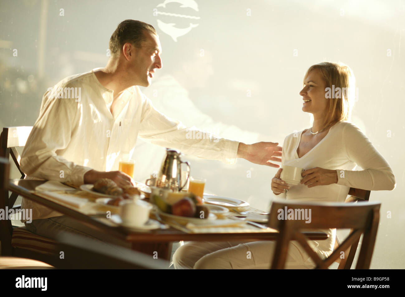 Mate sitting breakfast-table entertains opposite semi-portrait 40-50 ...