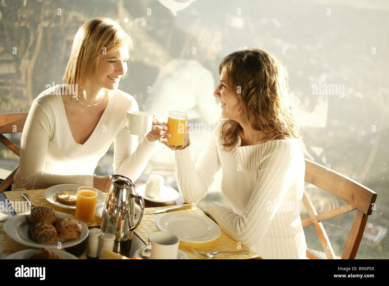 Women sitting breakfast-table across the way drinks smiling portrait 18 ...