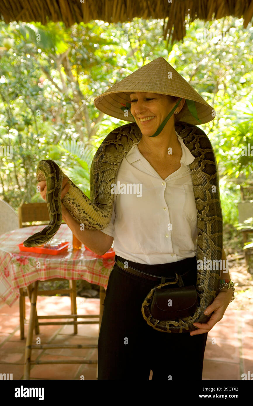 Tourist woman holding a python in Vietnam Stock Photo - Alamy