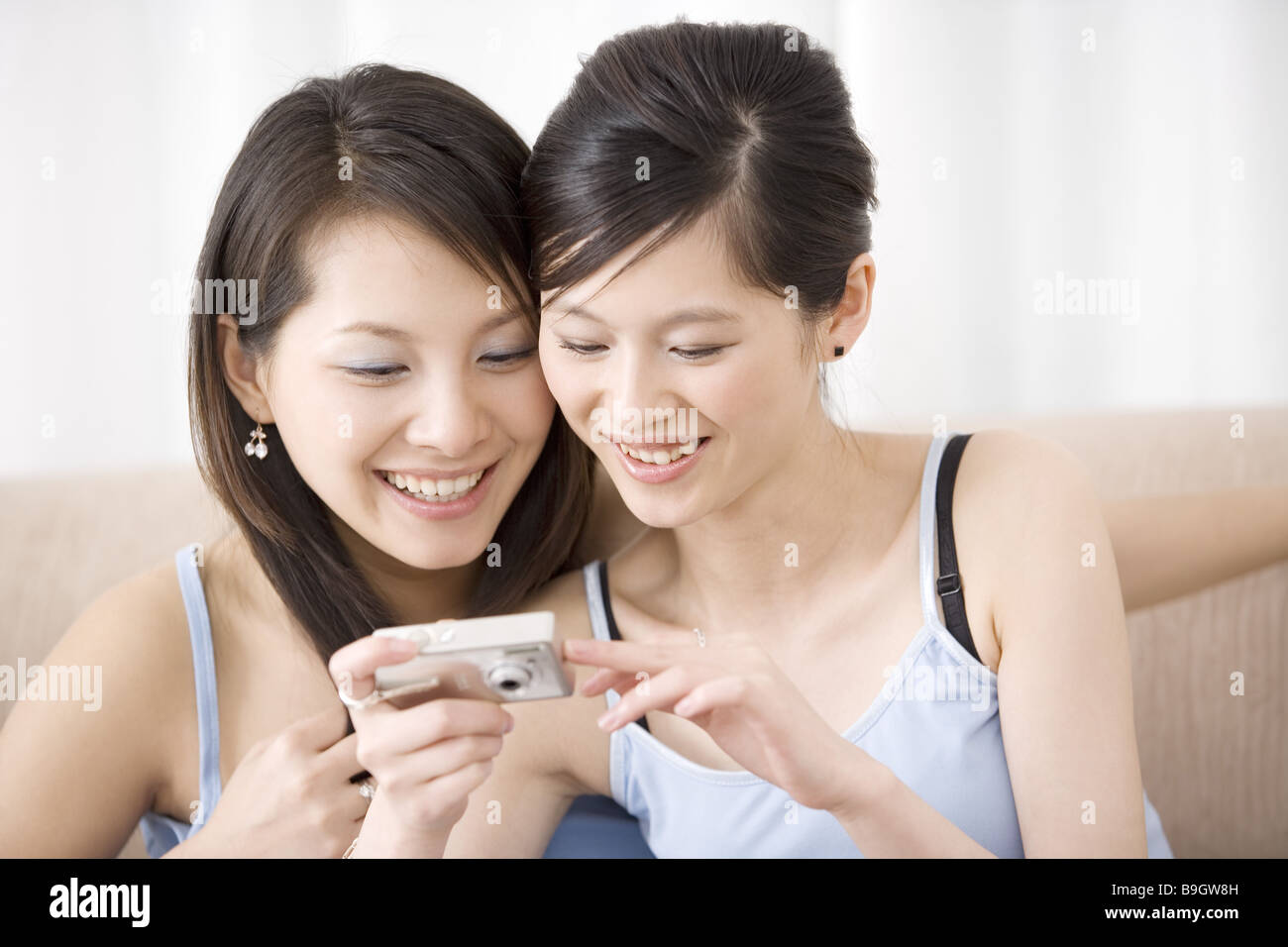 Two young women looking at digital camera smiling portrait Stock Photo ...
