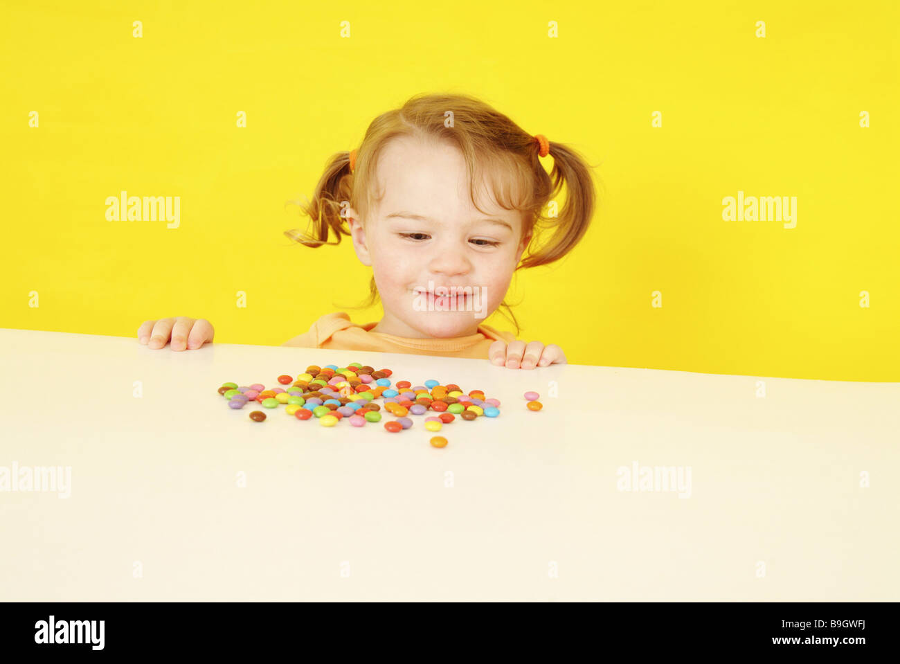 Laugh child girl candies cheerfully Stock Photo - Alamy
