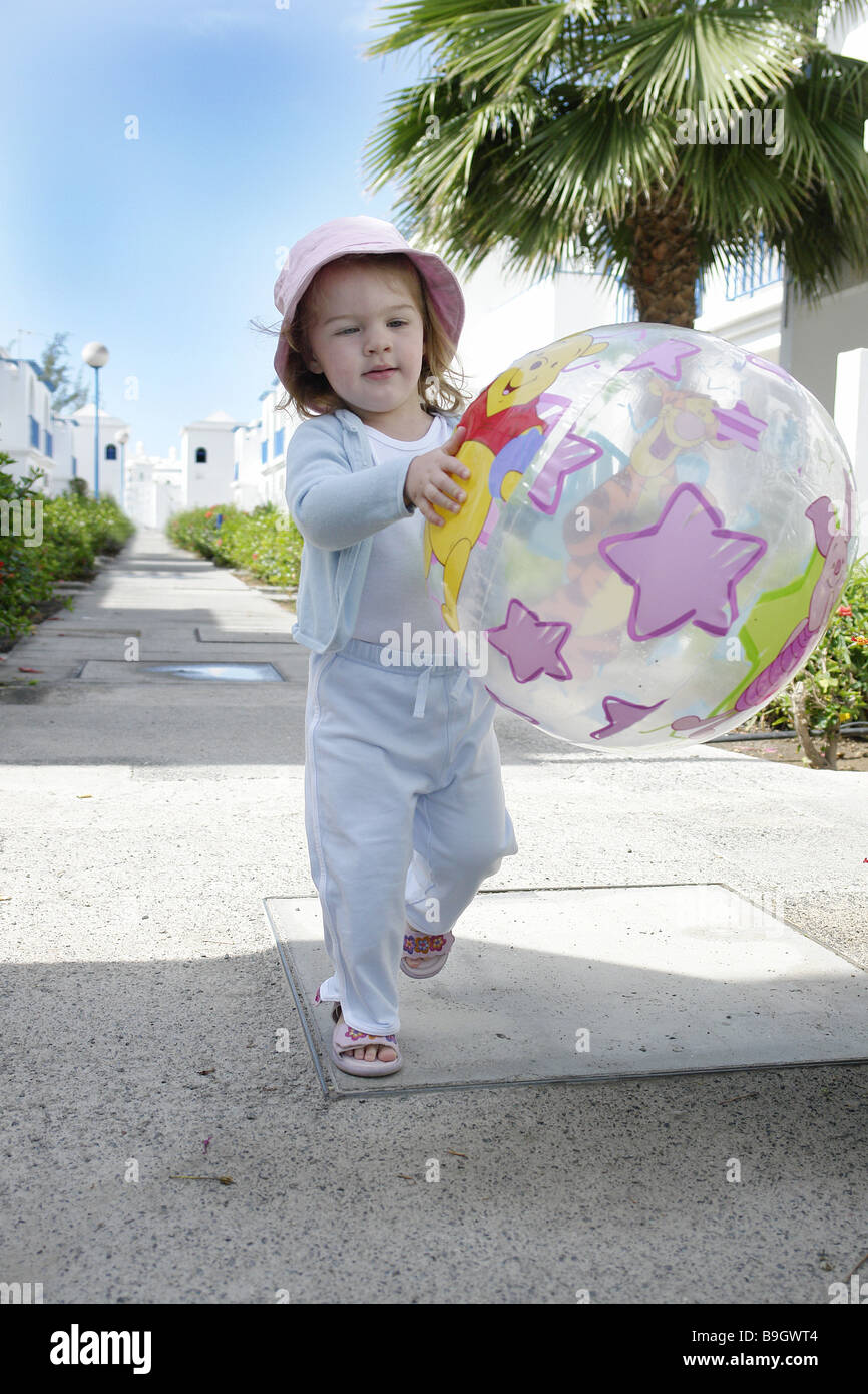 Toddler water-ball plays runs Stock Photo - Alamy