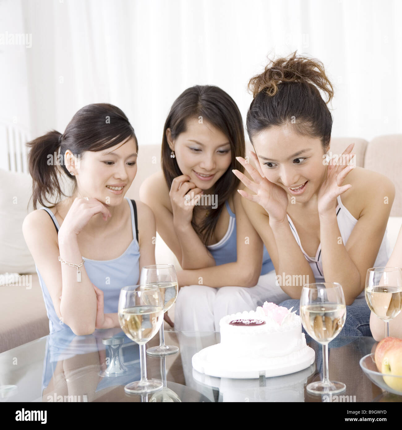 Four young women looking at cake smiling portrait Stock Photo - Alamy