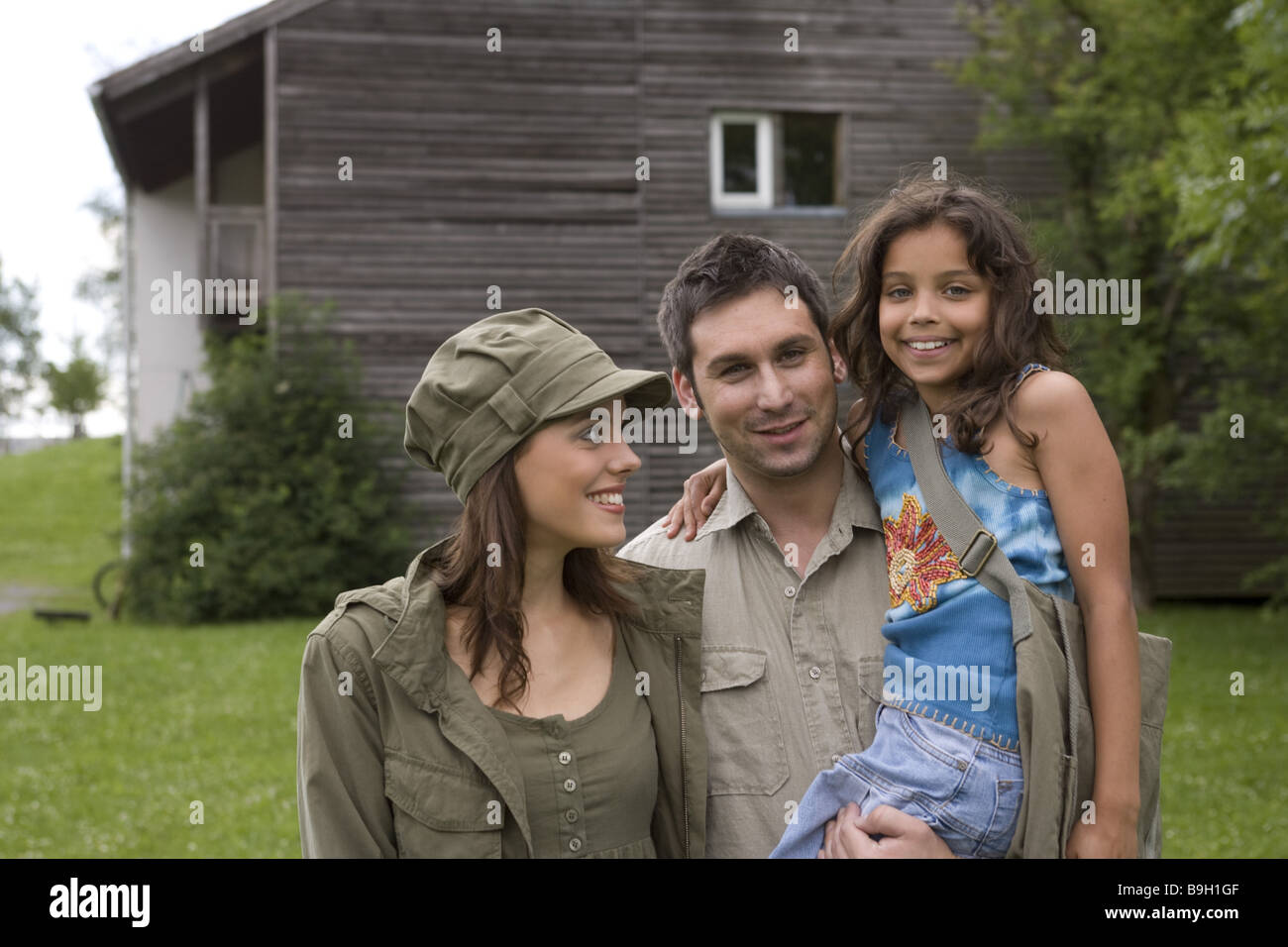 Family stands smiling garden embraces semi-portrait 10-12 years 11 year ...