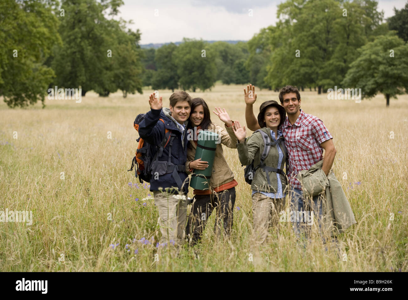 Group hikes leisure time nature grass waves smiling gesture outside 20 ...