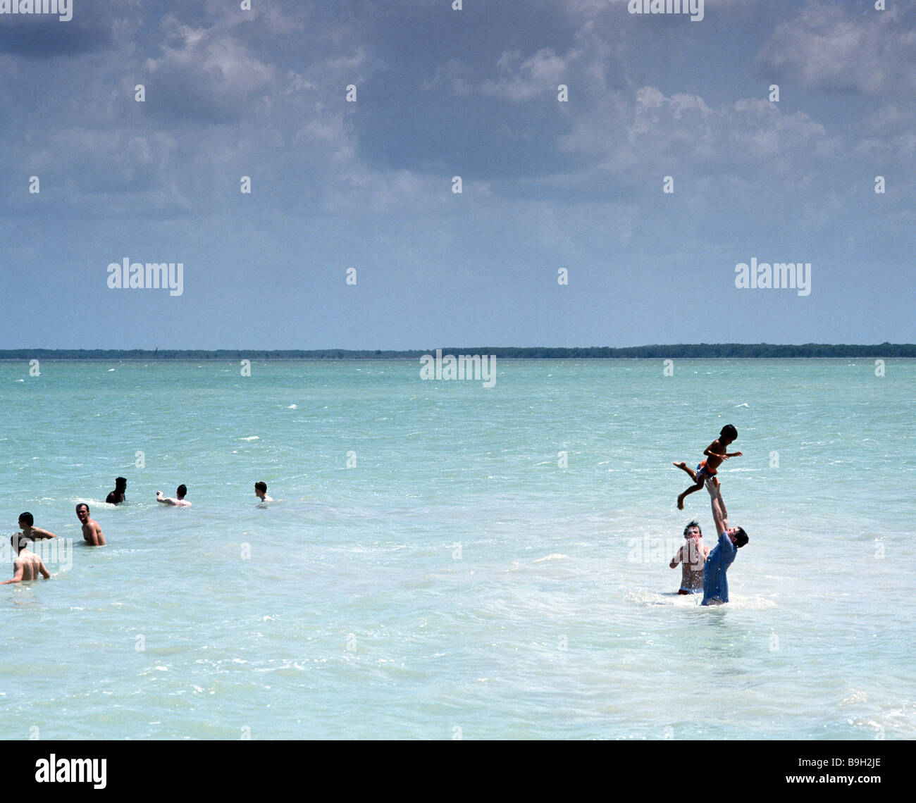 Group of children and adult playing in the Caribbean Sea Corozal ...