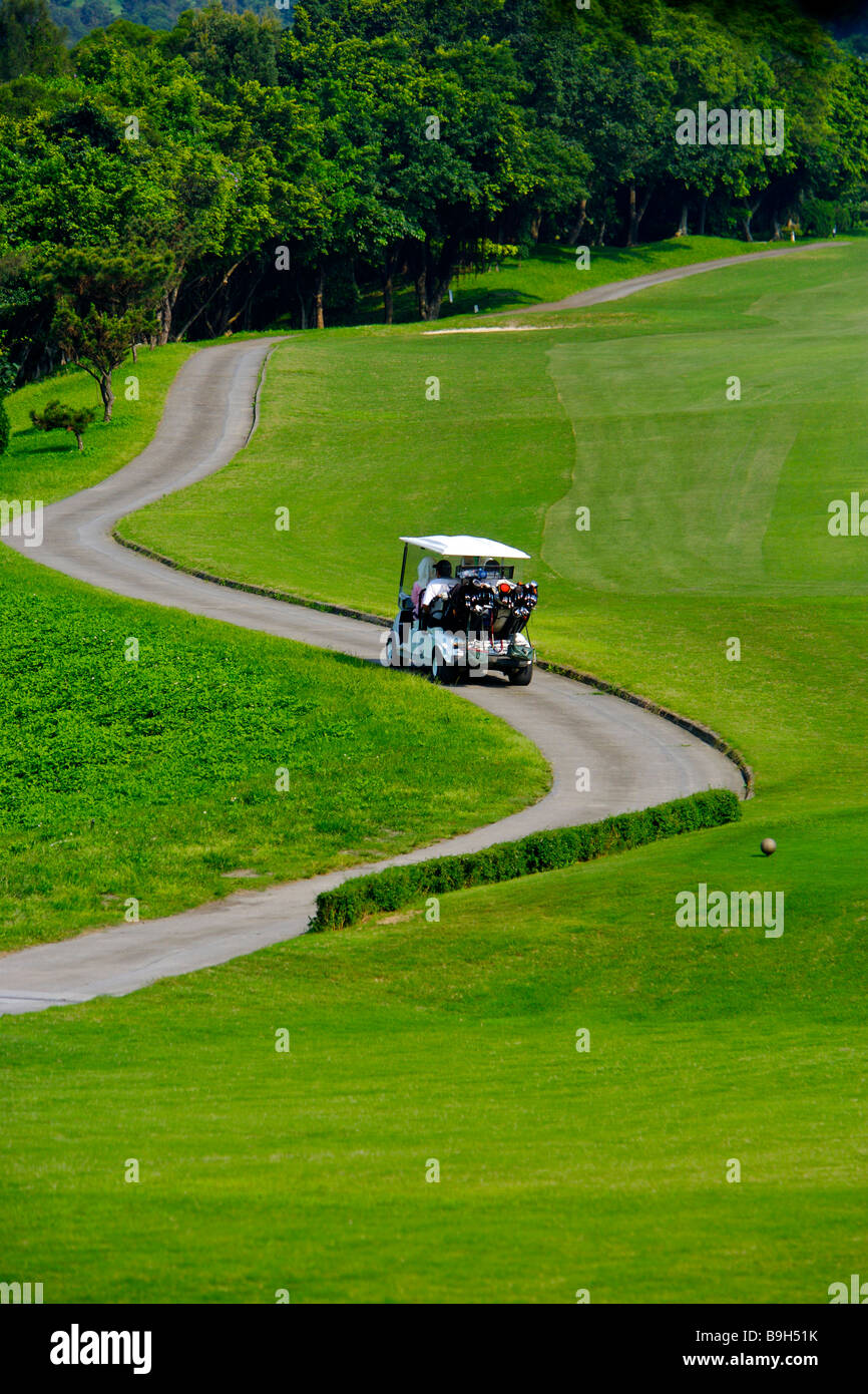 Golfer driving cart on single lane road Stock Photo - Alamy