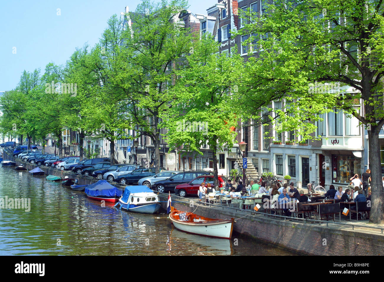 Netherlands Amsterdam cityscape canal boats shore people summer ...