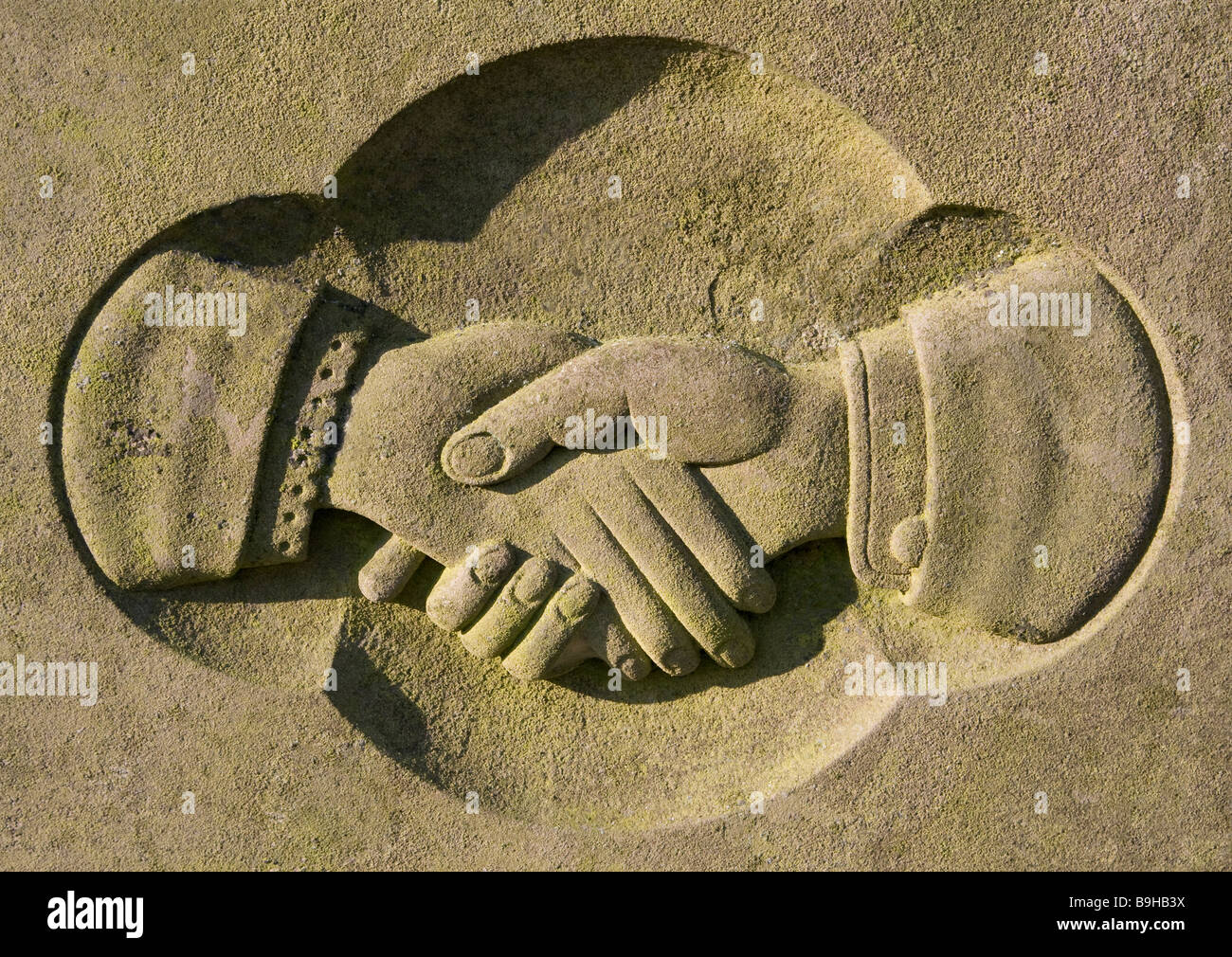 Handshake carved in stone Stock Photo - Alamy