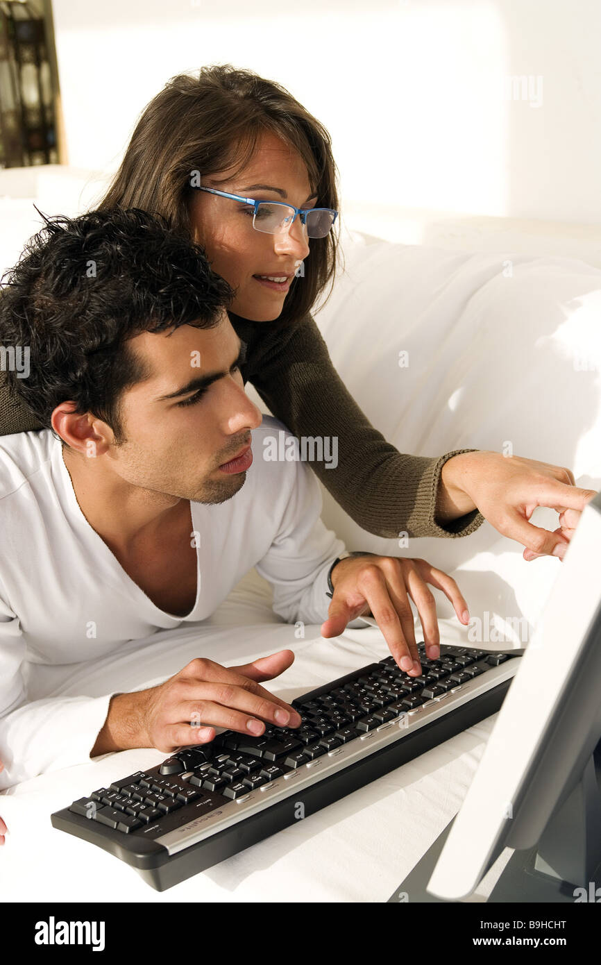 Mate young couch computers 20-30 years working prone position glasses ...