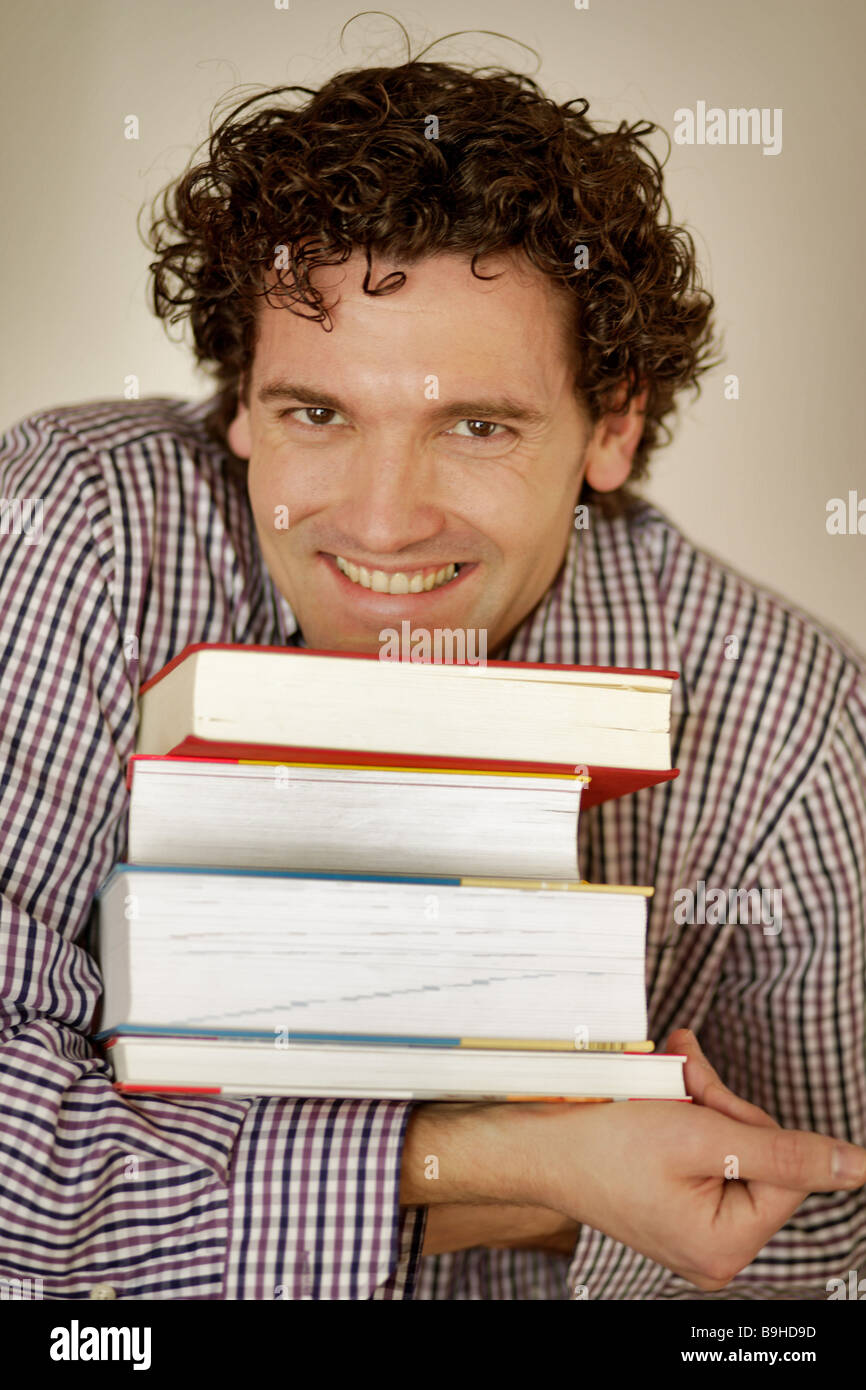 Man smiling deck of books holding portrait Stock Photo - Alamy