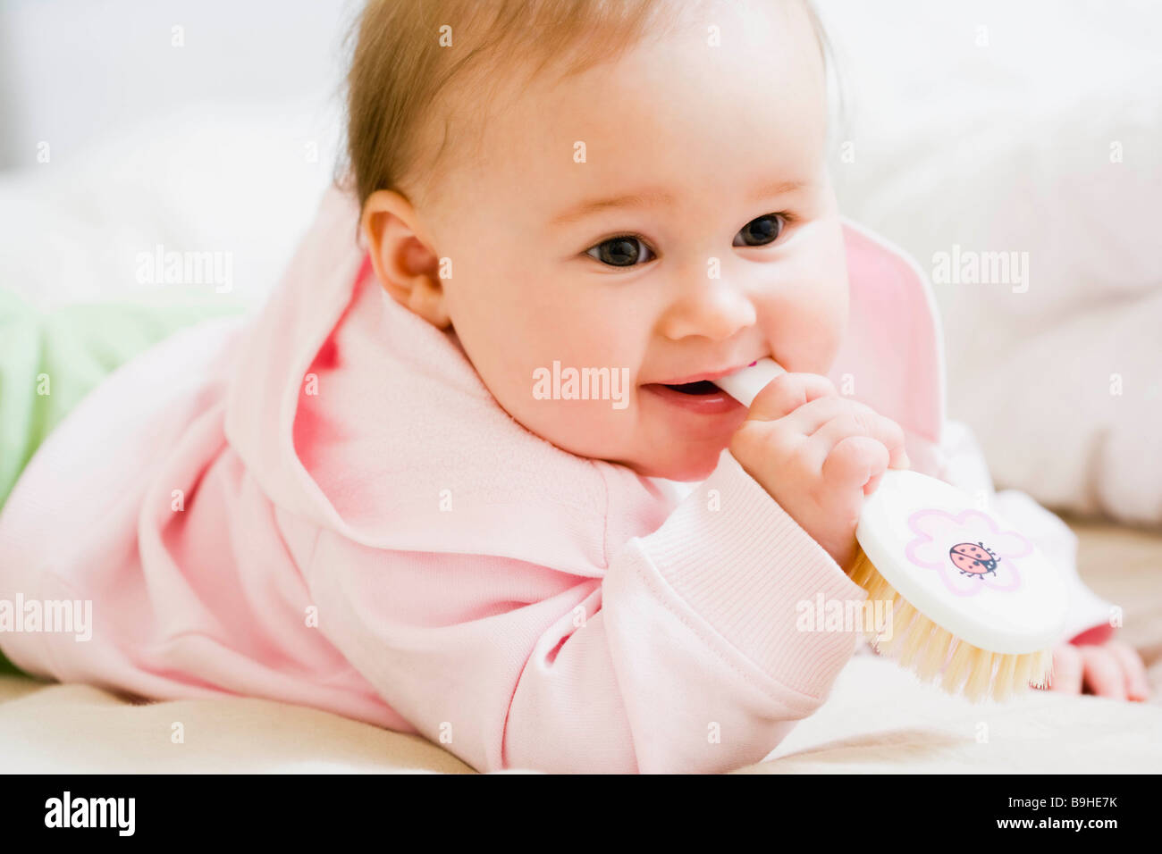 Baby holding hairbrush Stock Photo - Alamy