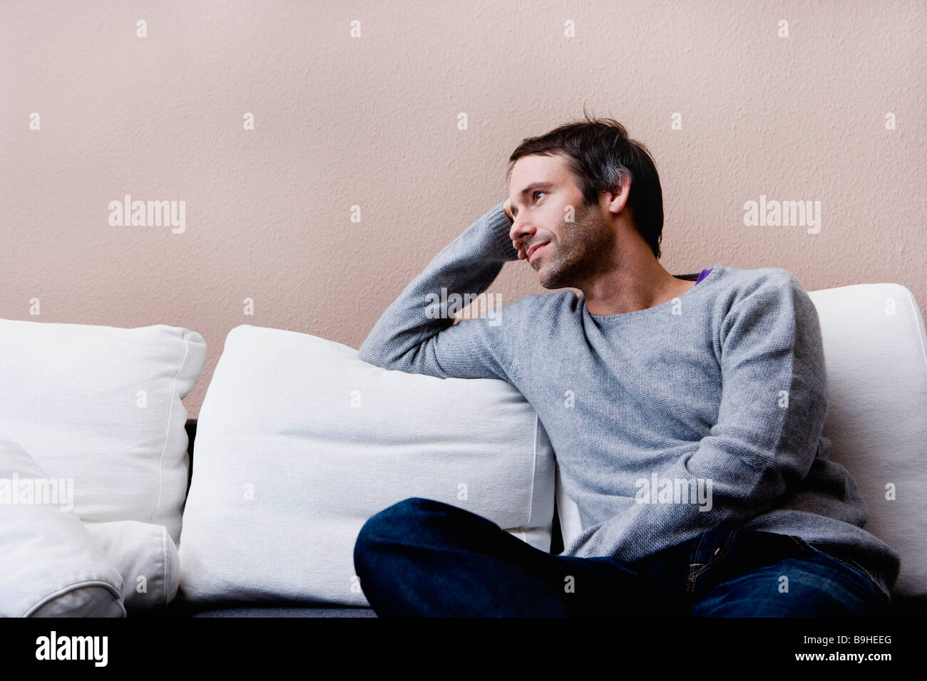 Man sitting on couch Stock Photo - Alamy