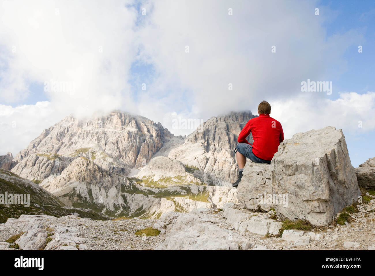 Man Sitting On Rock Looking Stock Photos & Man Sitting On Rock Looking ...