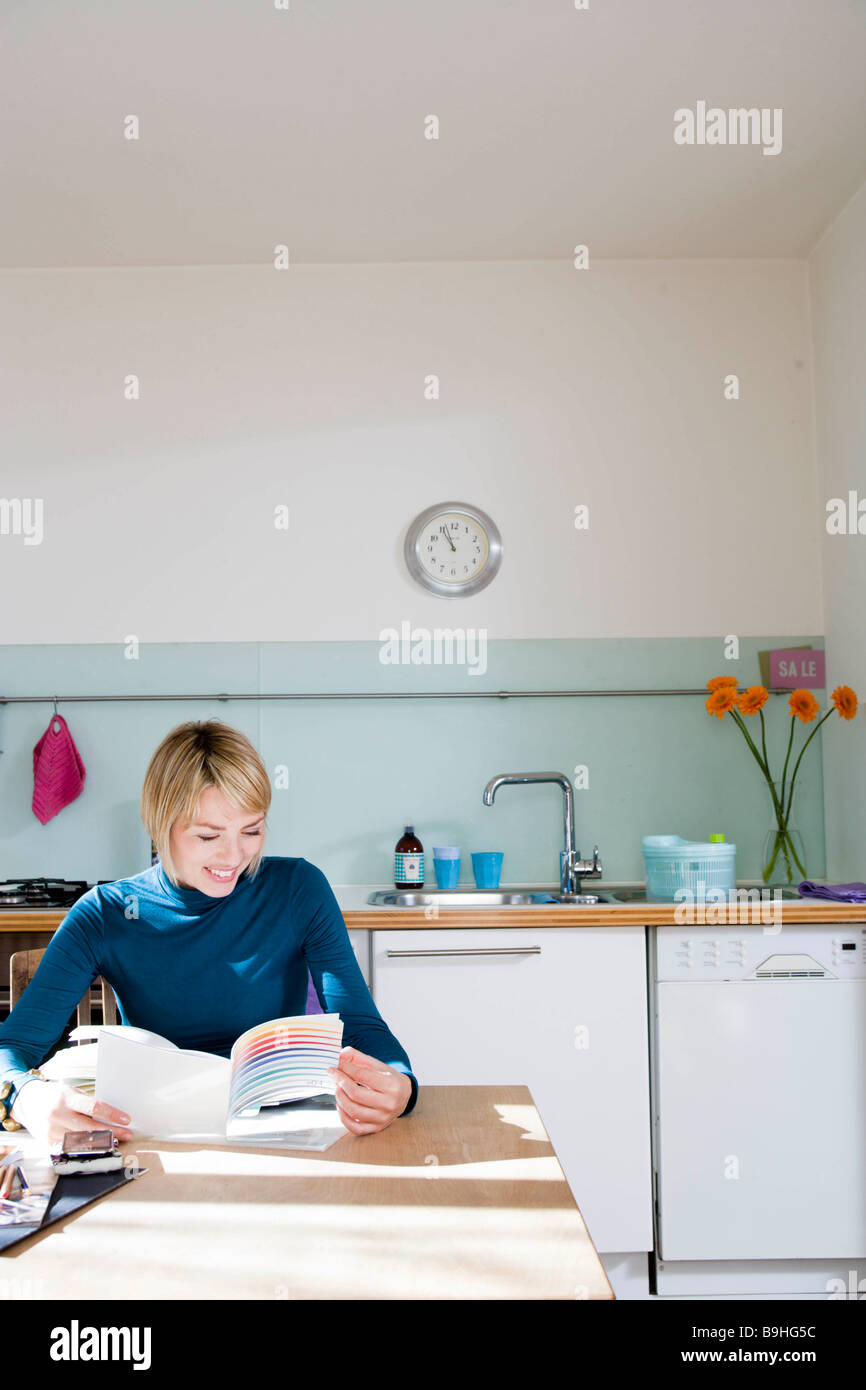 Woman sitting in kitchen Stock Photo - Alamy