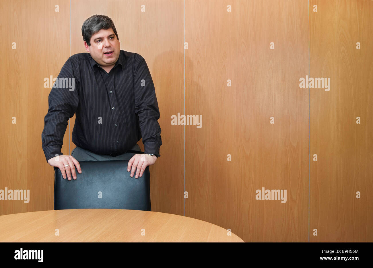 Man standing talking in boardroom Stock Photo - Alamy