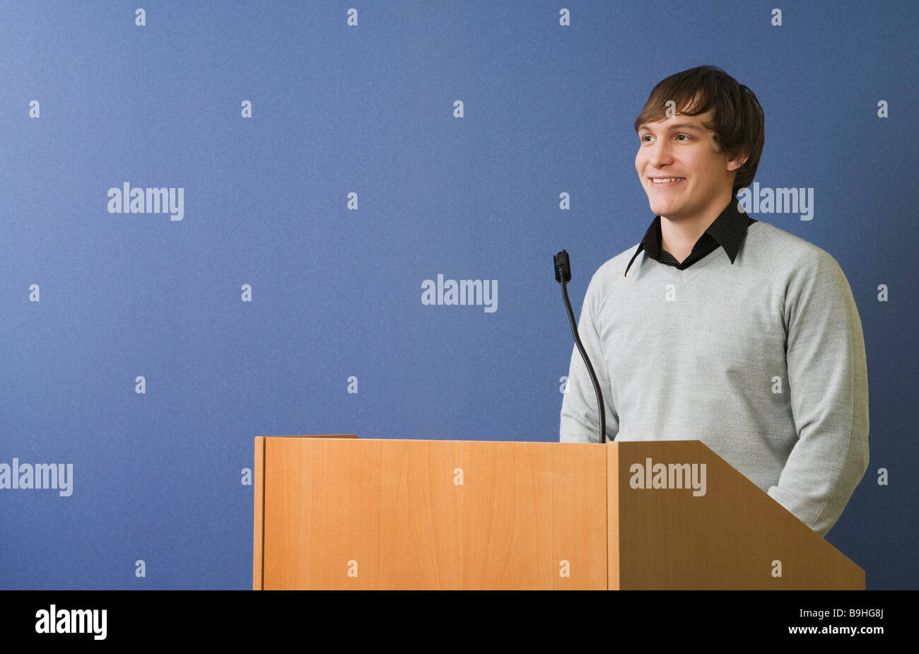Man standing at lectern Stock Photo - Alamy