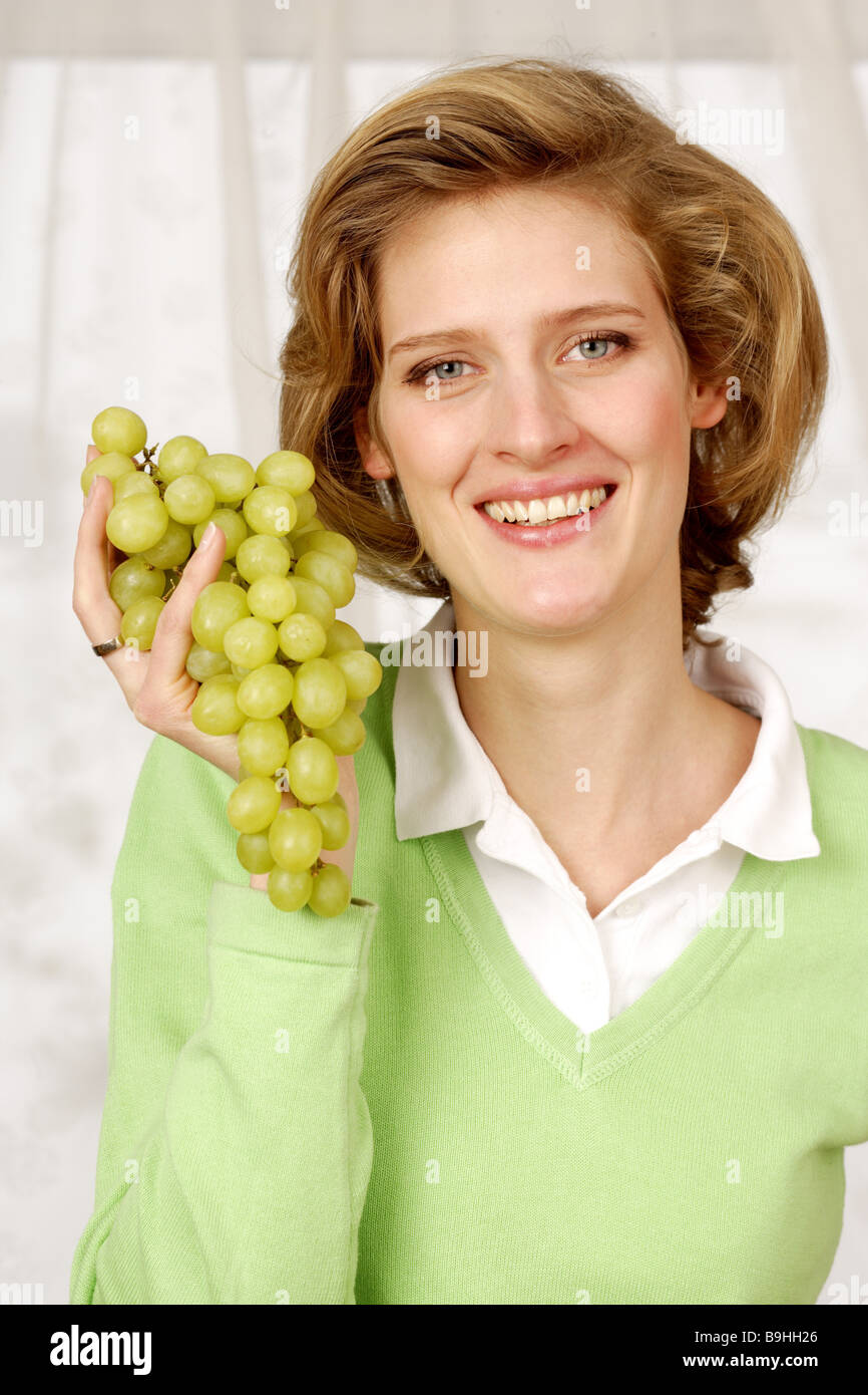 Woman smiling grapes holding portrait Stock Photo - Alamy