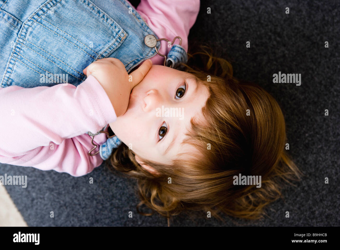 Child laying on carpet Stock Photo - Alamy