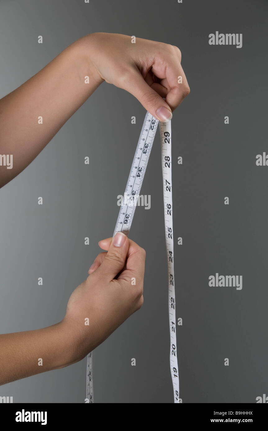 Female hands holding tape measure Stock Photo - Alamy