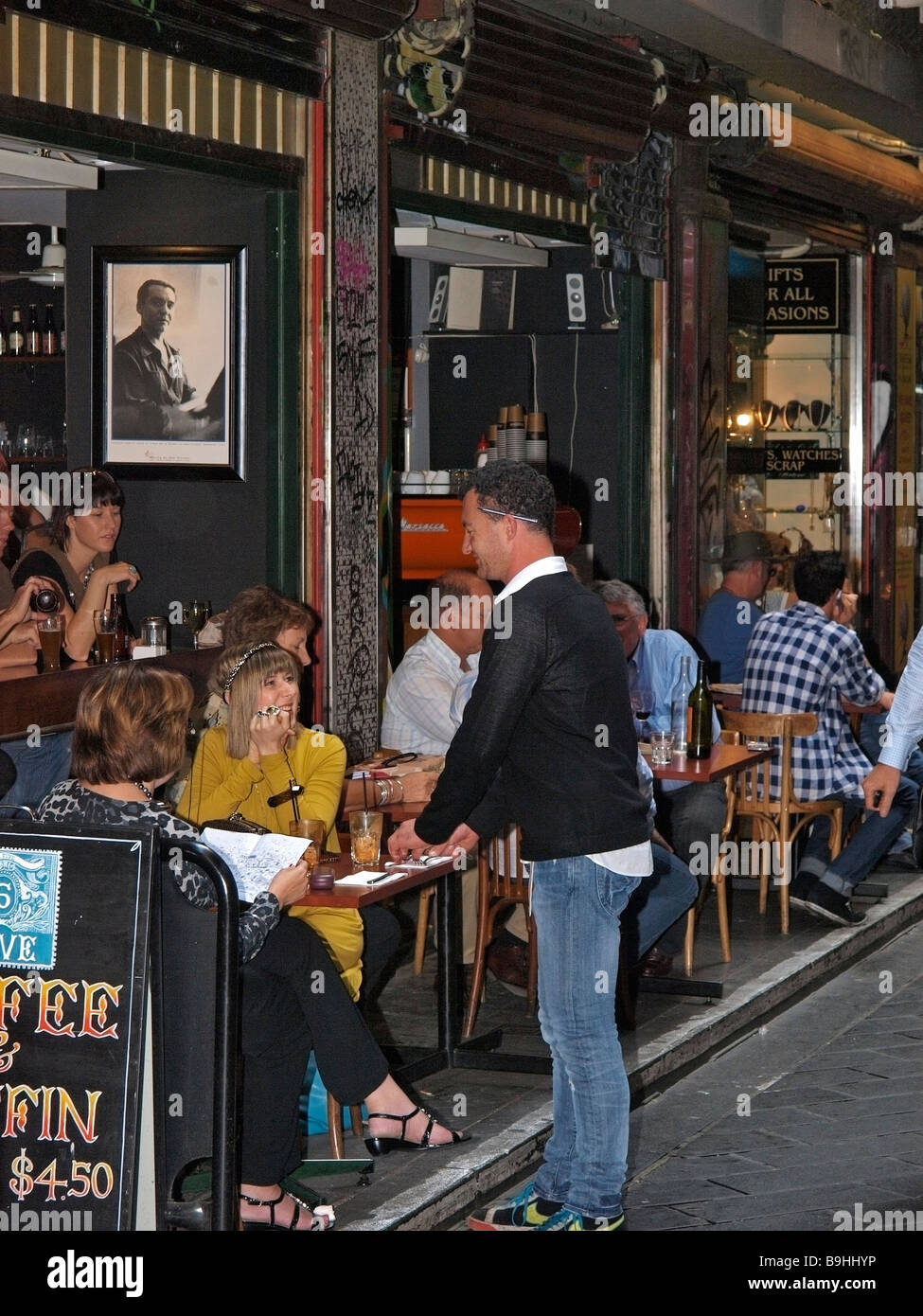 WAITER TALKING TO CUSTOMERS SITTING AT TABLE, CAFE CENTRE PLACE ...