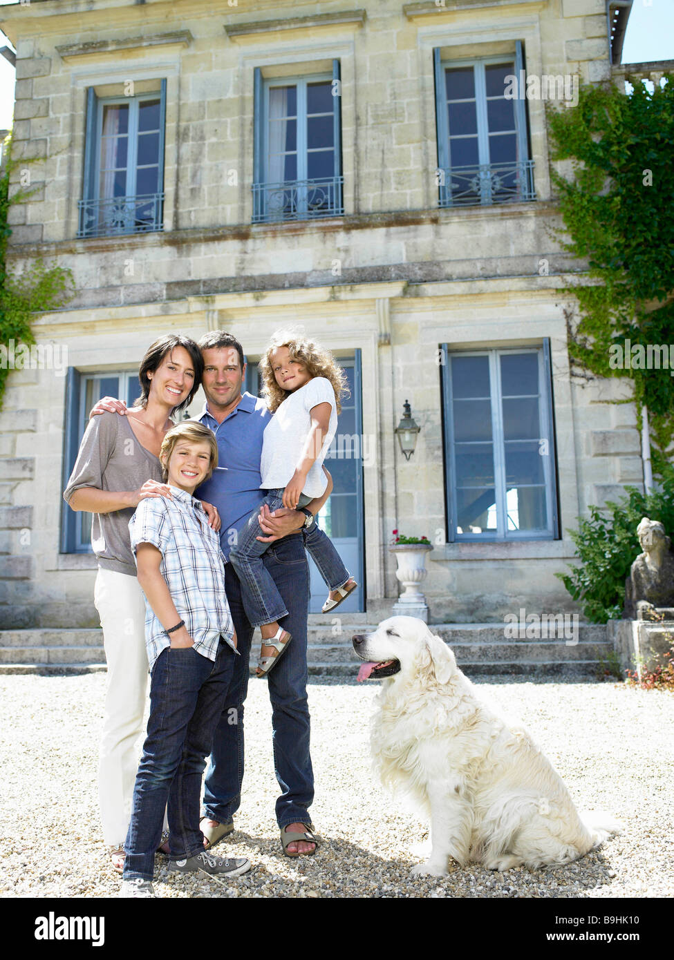 Family standing in front of a house Stock Photo - Alamy