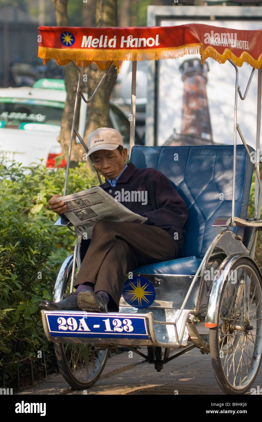 Cyclo driver reading a newspaper, Hanoi, Vietnam Stock Photo - Alamy
