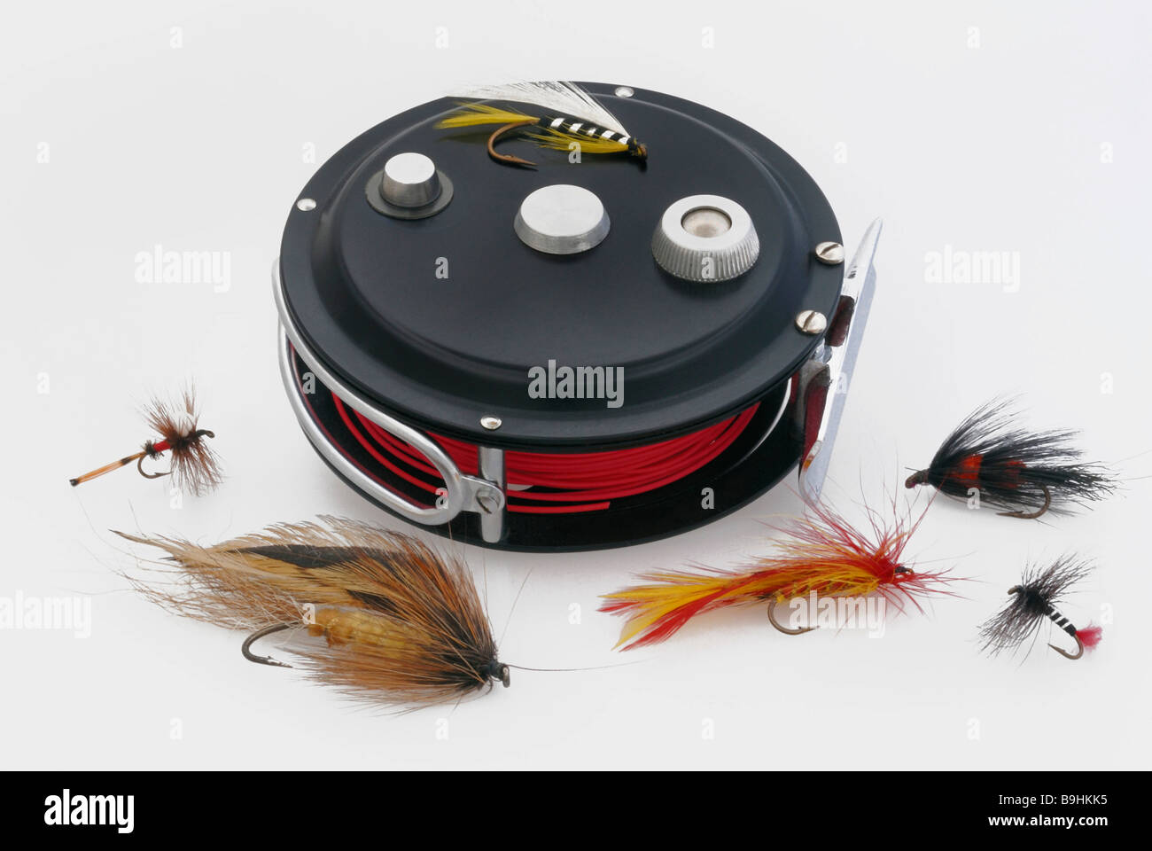 Reel with a red cast line and a variety of flies for fly fishing Stock ...